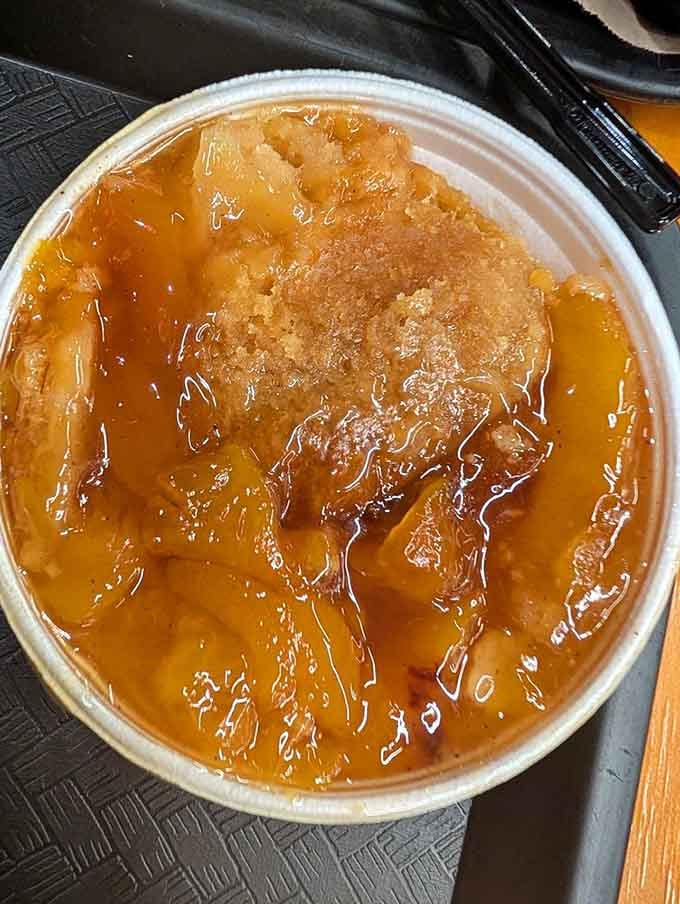 Golden, bubbling peach cobbler that looks like your grandmother's Sunday dessert decided to show up at a legendary Texas barbecue joint.