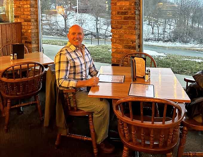 The smile of a man who just found his new favorite table by the window. Completely understandable, honestly.