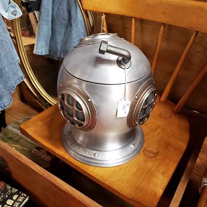 A vintage deep-sea diver helmet sitting on a wooden chair, casually waiting for its next underwater adventure.