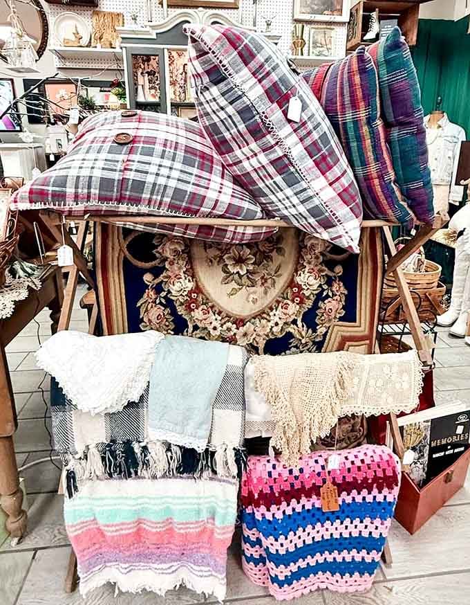 Plaid pillows, woven blankets, and crocheted throws stacked together like a cozy grandmother's living room dream.