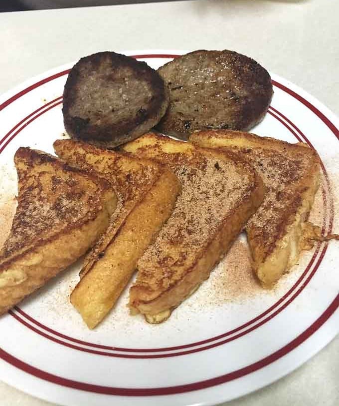 French toast dusted in cinnamon sugar alongside sausage patties, a plate that makes Saturday mornings worth celebrating.