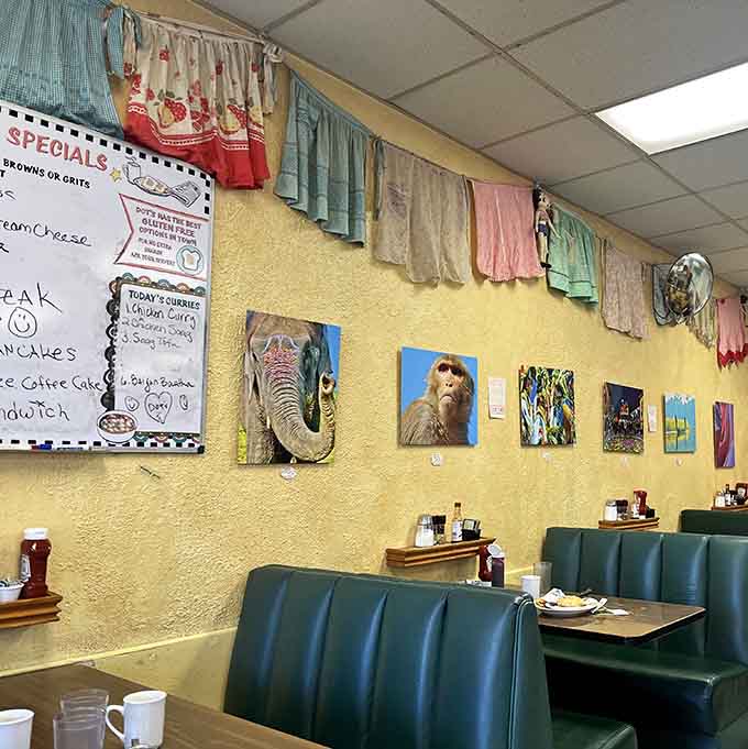 Vintage aprons strung along the wall, colorful paintings below. This diner decorates like your most interesting aunt.