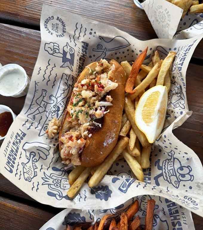 A lobster roll stuffed generously into a toasted bun, served with fries and a lemon wedge. New England called. California answered better.