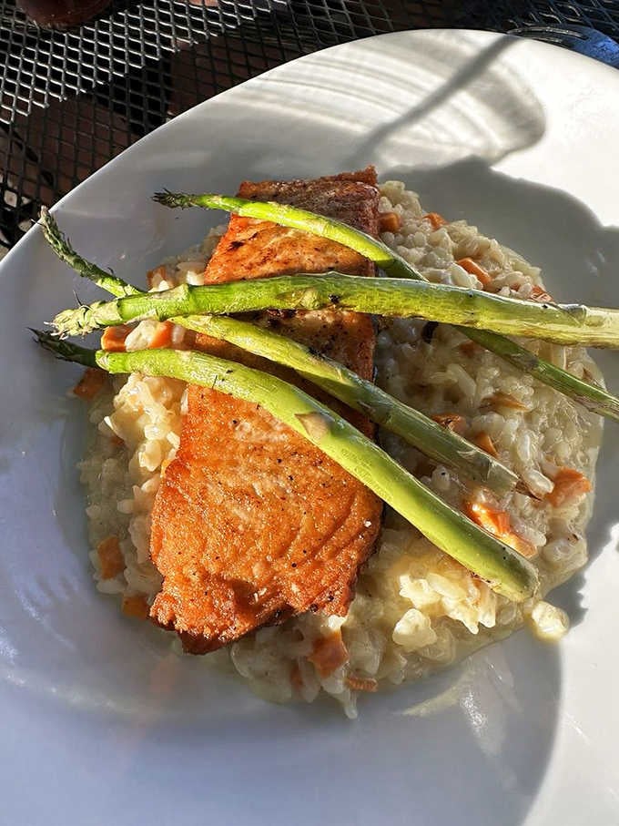 Seared salmon over risotto with asparagus spears standing at attention like tiny, delicious soldiers guarding your dinner.