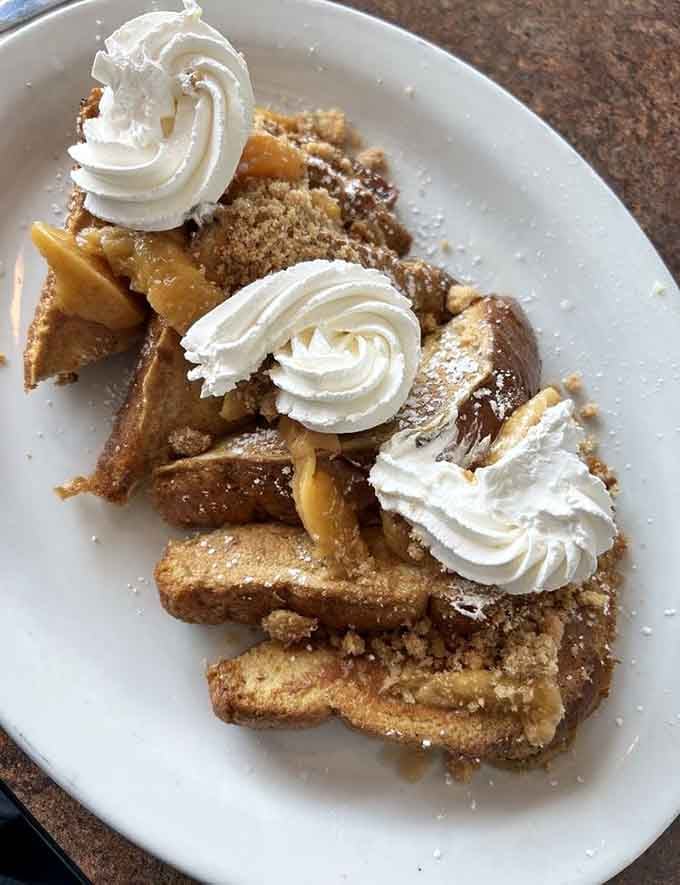 Peach cobbler French toast topped with whipped cream makes choosing between breakfast and dessert completely unnecessary and wonderfully indulgent.