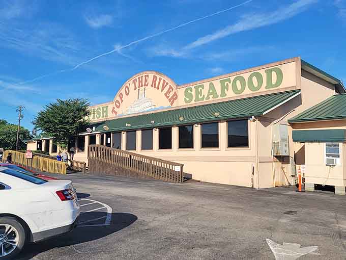 Top O' the River's cheerful green-roofed building promises exactly what the sign says, fresh seafood and zero pretension included.