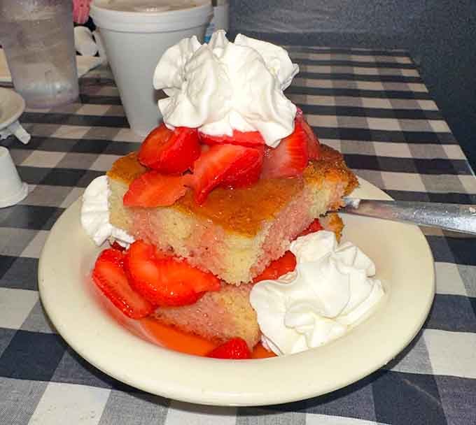 Fresh strawberries cascading over golden cake with clouds of whipped cream, dessert doesn't get more joyfully straightforward than this.