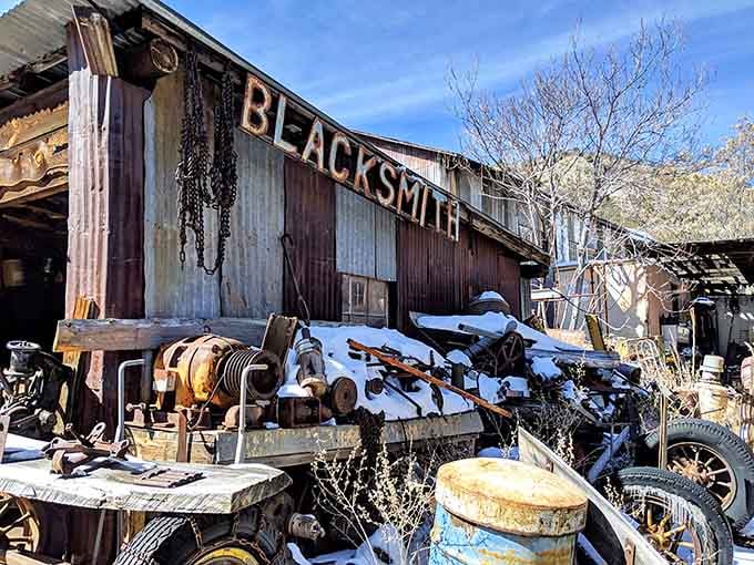 The blacksmith shop stands ready for work, chains hanging like industrial wind chimes waiting for the forge.