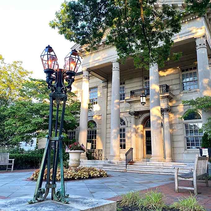 Haddonfield Borough Hall glows at golden hour, gas lamps lit, columns gleaming, looking effortlessly magnificent.