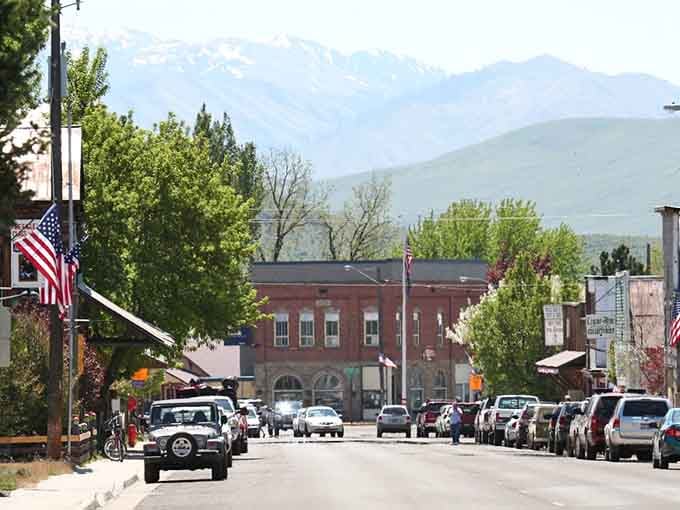 American flags lining the street, a handsome brick building anchoring the block, and mountains standing guard at the far end.