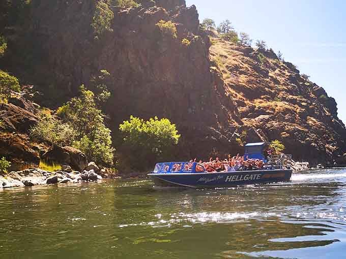 Towering canyon walls dwarf the boat below, reminding passengers that nature always has the best special effects budget.