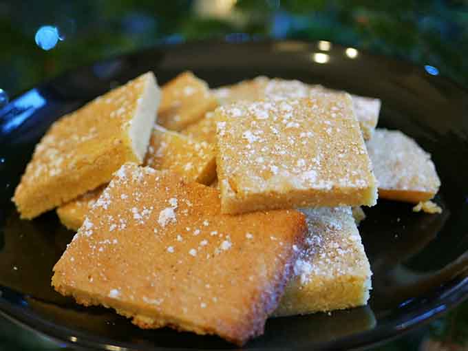Dusted with powdered sugar and stacked on a dark plate, these eggnog bites are proof that good things come in small, golden squares.