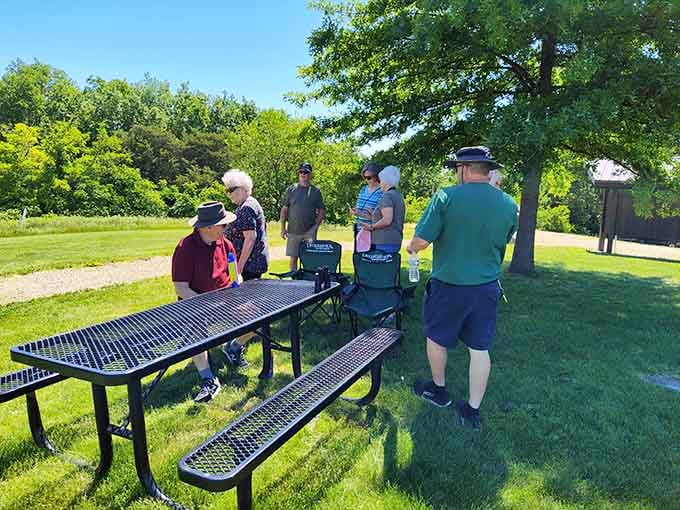 Picnic tables positioned for prime people-watching and nature-gazing, the perfect spot for philosophical sandwich consumption.