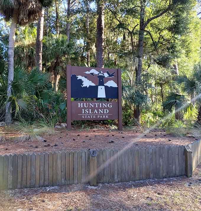 The park sign says Hunting Island State Park, but the lighthouse peeking above it is clearly the real headliner.