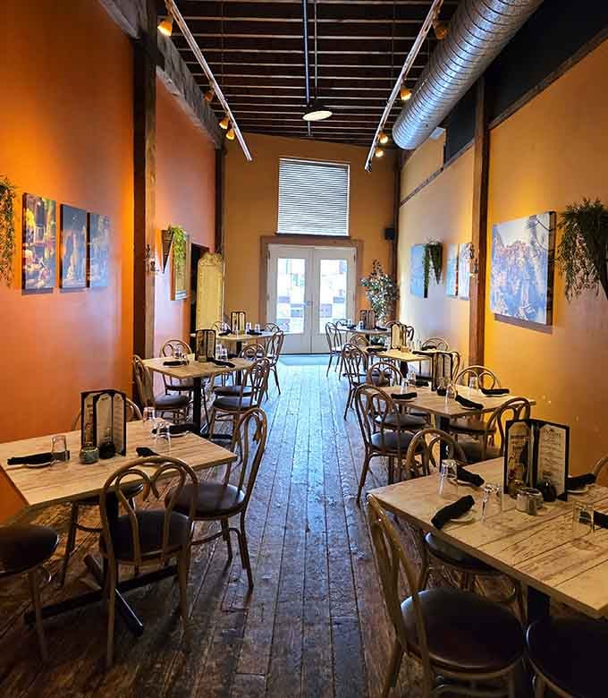 The second dining room glows amber and warm, with worn wooden floors that have stories older than most of us.