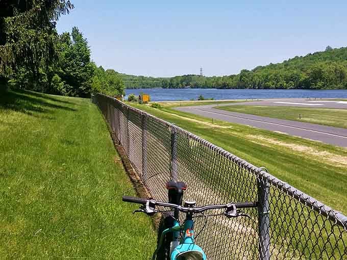 A bike parked along the fence with the airfield and lake beyond, the view alone is worth the whole trip.