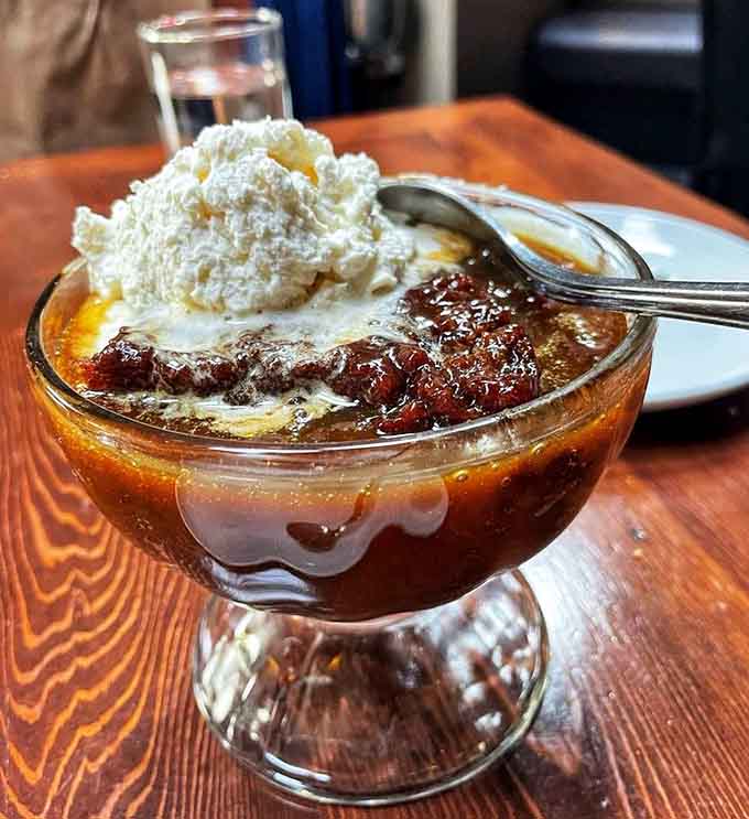 Sticky toffee pudding bubbling with caramel and topped with whipped cream. Dessert doesn't get more honest or more irresistible than this.