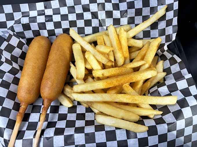 Two corndogs and a basket of seasoned fries. Classic American comfort food, served exactly the way it should be.