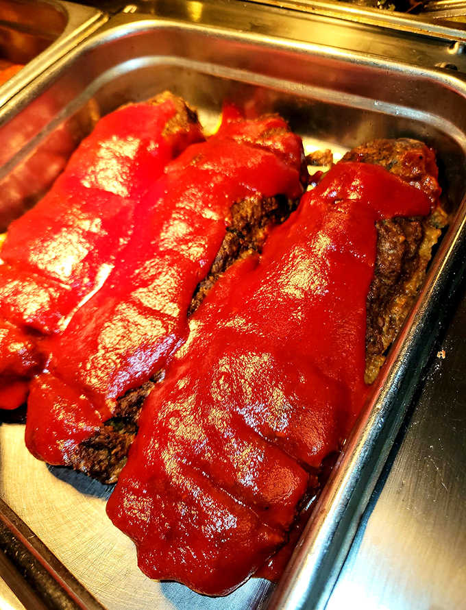 Three gorgeous loaves of meatloaf glazed in rich tomato sauce, sitting in the buffet pan like royalty waiting to be served.