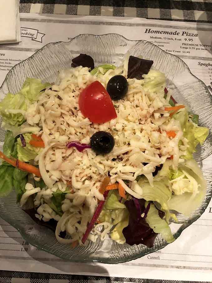 Mama Santa's salad, generously topped with shredded cheese, olives, and tomato, proves vegetables can absolutely steal the show.