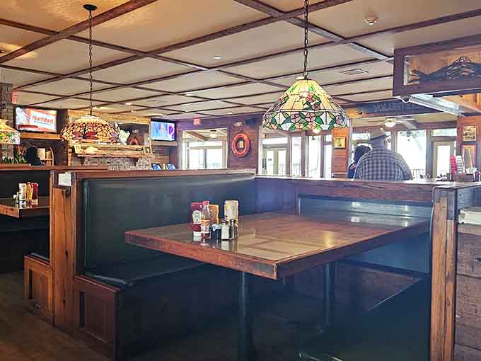Green leather booths, Tiffany-style pendant lamps, and marsh light through the windows. Comfort lives here.