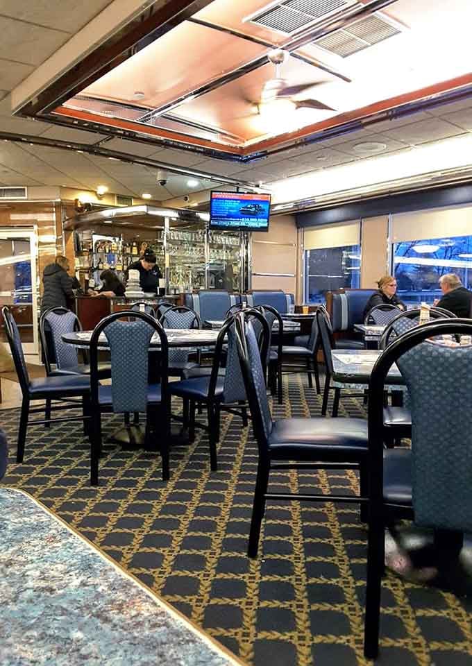 Blue chairs, warm lighting, and a ceiling fan spinning overhead, this dining room has a rhythm all its own.