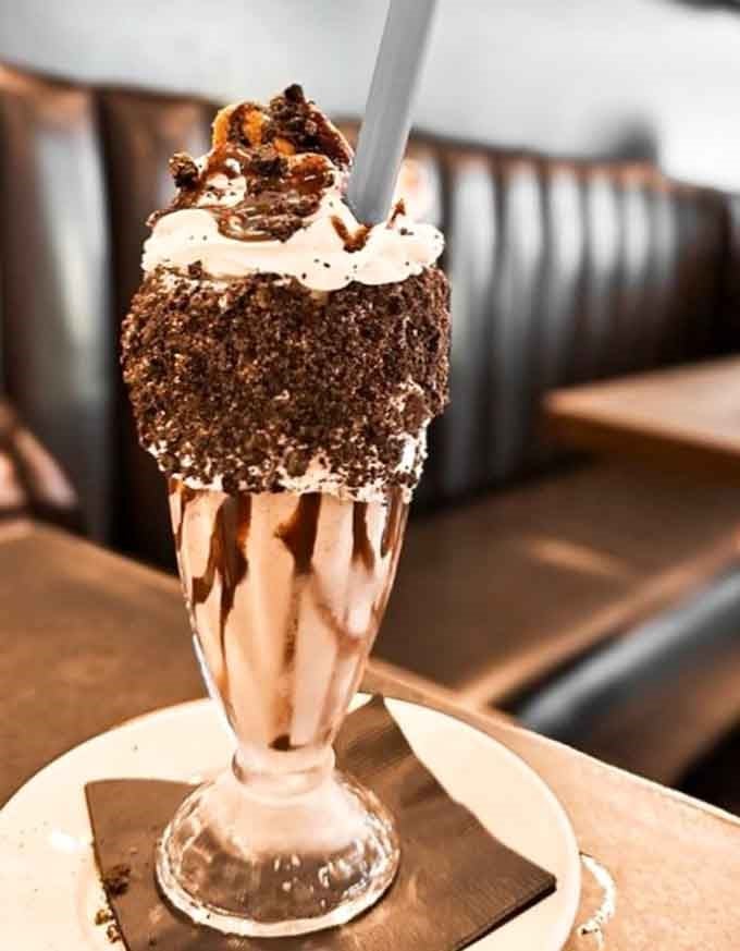 That chocolate shake, rimmed with crumbled cookies and piled high with whipped cream, is dessert wearing a tuxedo.