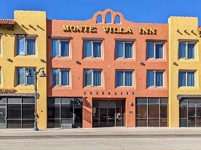 The Monte Villa Inn's warm terracotta facade stands bold against a brilliant blue sky, looking like a welcoming postcard from the American Southwest.
