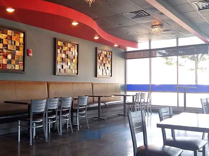 Long booths, mosaic artwork, and floor-to-ceiling windows flooding the room with light. This space genuinely wants you comfortable.