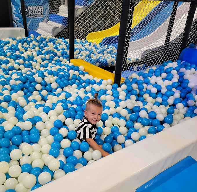 Buried in a sea of blue and white balls, this little one has officially found the best seat in the house.