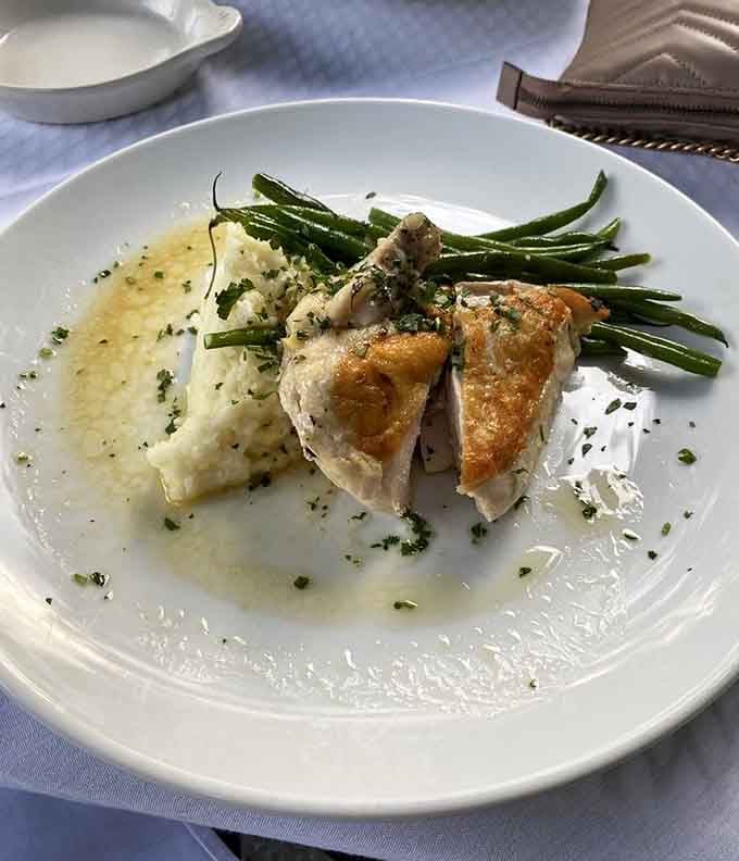 Roasted chicken with silky mashed potatoes, crisp green beans, and a bright herb butter sauce, a classic done with quiet confidence.