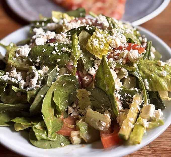 Crisp greens, crumbled feta, and fresh vegetables tumbled together beautifully. A salad that actually makes you glad you ordered it.