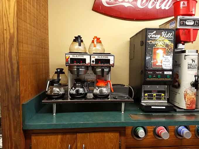 A proper coffee station with a vintage Coca-Cola sign overhead, mornings here start on the right foot.