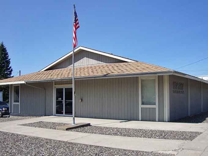 The Pomeroy Post Office flies its flag proudly against a brilliant blue sky, a straightforward building doing straightforward, essential work every day.