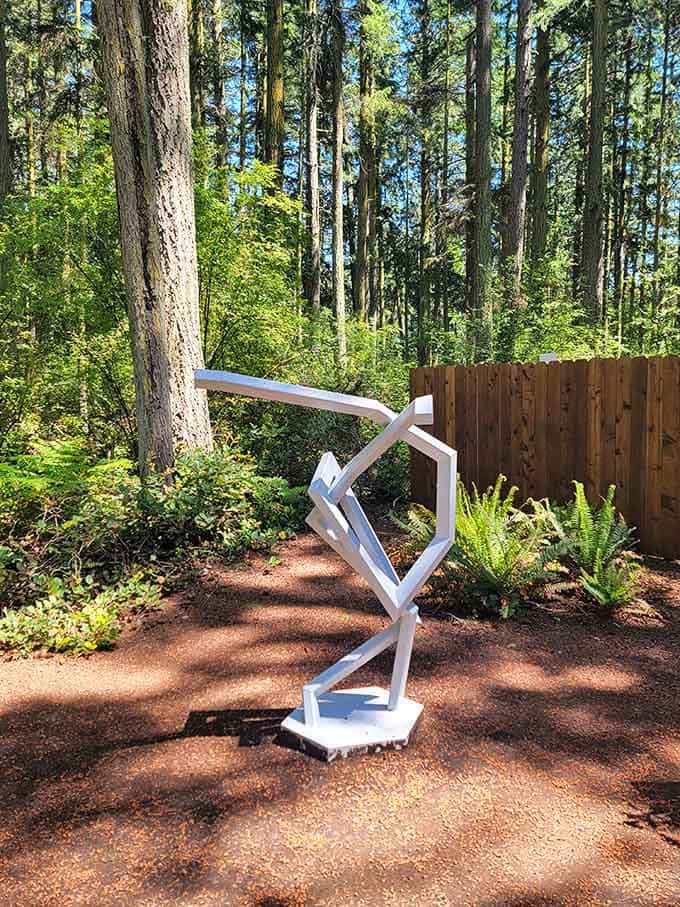 A crisp white geometric sculpture stands confidently among the trees, angular and bold against all that soft Pacific Northwest green.