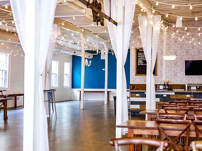 String lights and white curtains transform industrial space into something that feels almost magical and inviting inside.