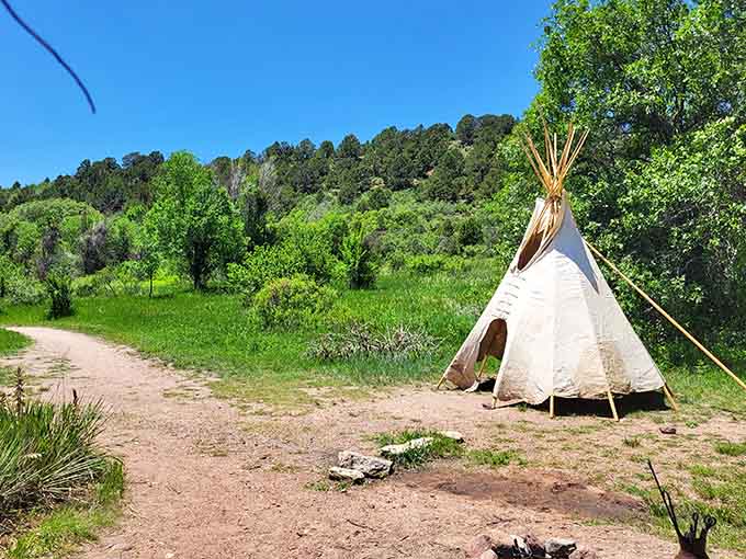 A tipi standing quietly against the green hillside, reminding you whose story started here first.