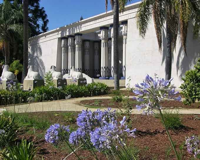 White columns, sphinx statues, and purple blooms frame the museum exterior, looking like a scene straight out of an epic Hollywood production.
