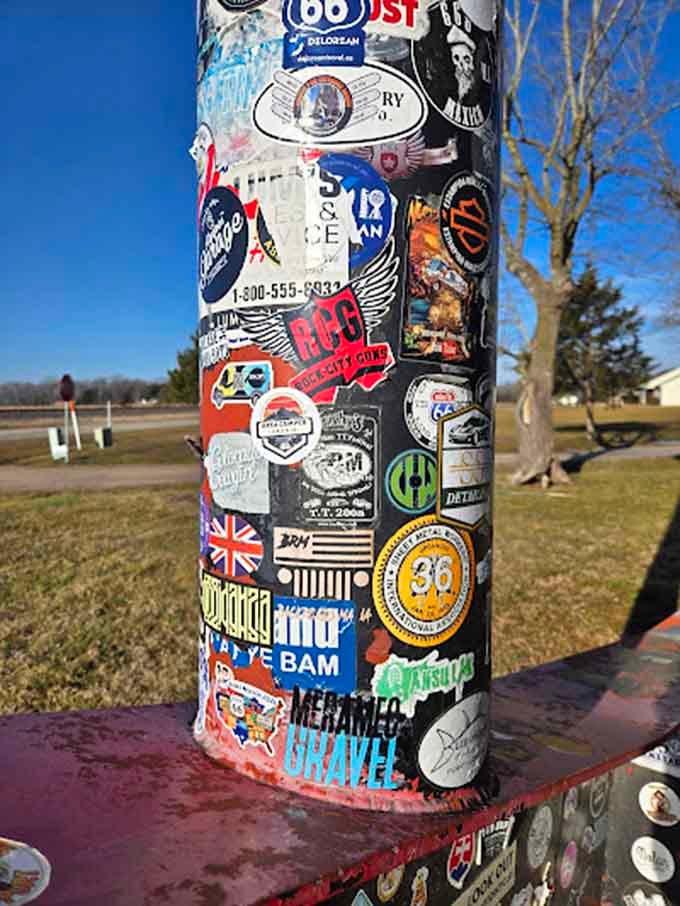 Hundreds of stickers from travelers worldwide cover the chair's legs, turning steel into a rolling scrapbook of the open road.
