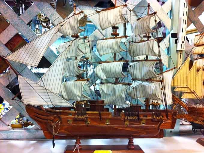 A tall-masted wooden ship sailing through a sea of antiques, commanding attention without saying a single word.