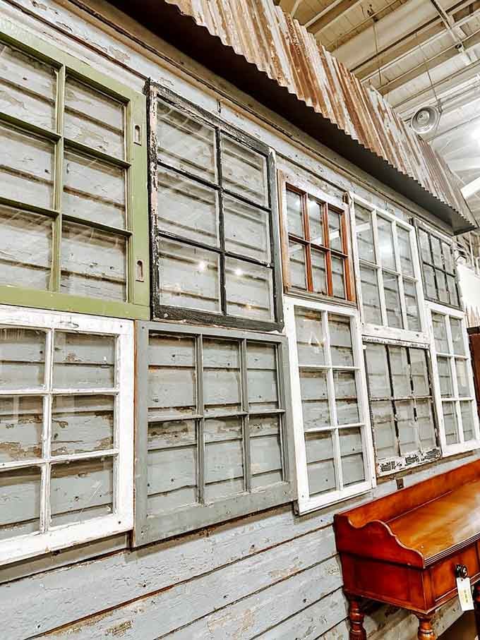 Dozens of old wooden window frames lined up together, each one carrying the quiet memory of a Baltimore home.