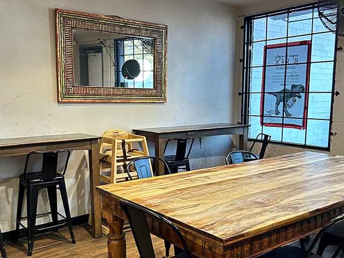 Wooden tables, a gilded mirror, and metal stools, proof that great food needs nothing fancy to feel like home.