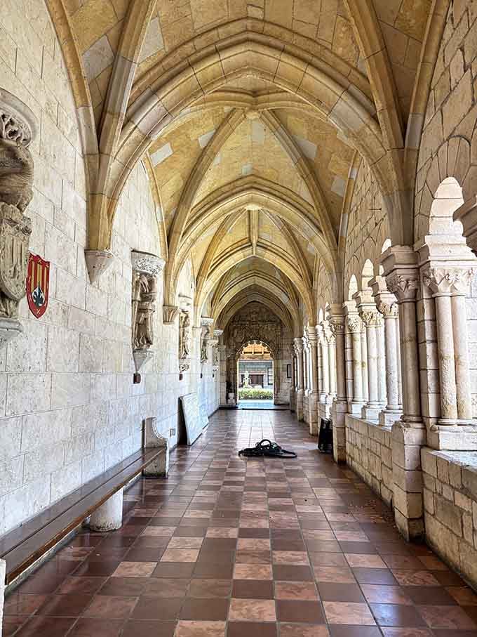 The cloister hallway stretches ahead like a corridor through time, and every arch invites you to keep walking.