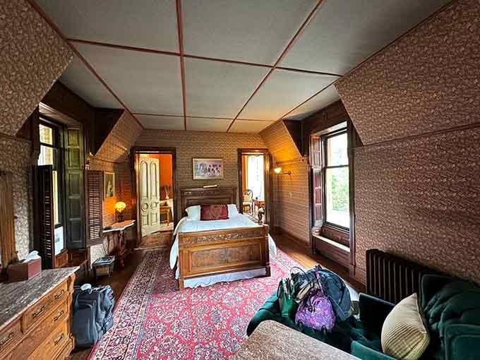 Patterned wallpaper, a carved wooden bed, and Persian rugs underfoot. Sleeping here means waking up inside a piece of history.