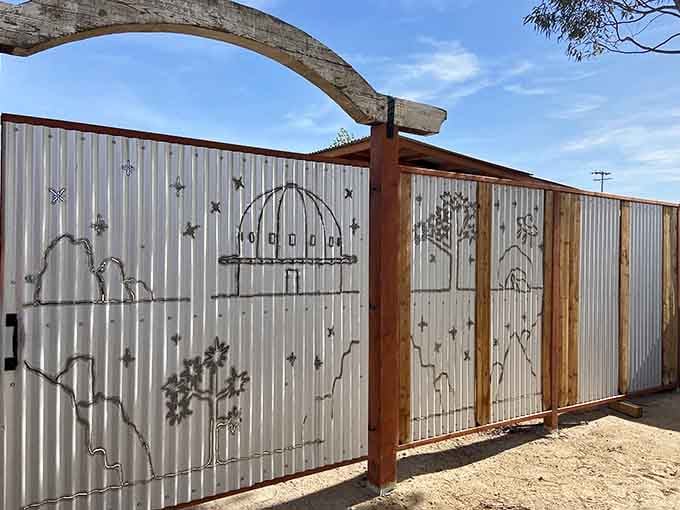 A hand-crafted metal gate depicting the dome against a starry sky, because the art here sets the mood before you even walk in.
