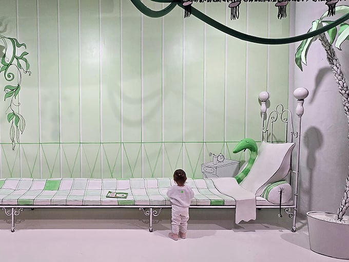 A toddler standing before an enormous green-striped bed — the Great Green Room is bigger and quieter than you'd ever imagine.