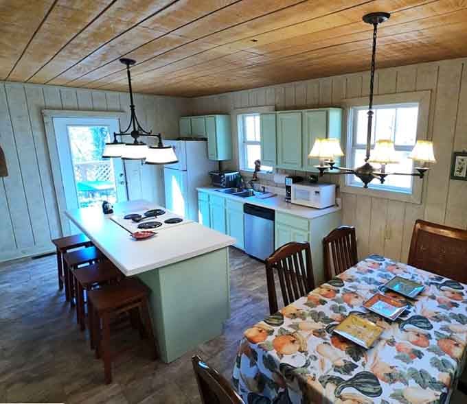 Sage green cabinets, a kitchen island, and pendant lights. Cooking here feels less like a chore and more like a ceremony.