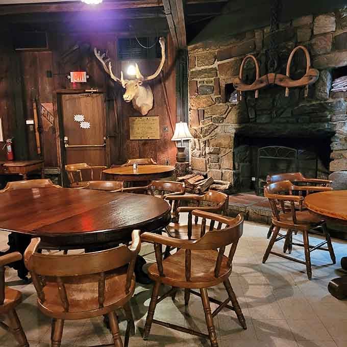 Stone fireplace, mounted antlers, and wooden tables create an atmosphere that's equal parts hunting lodge and cozy tavern.
