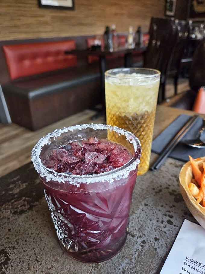 A deep purple cocktail with a salted rim walks into a railroad car ramen restaurant. This is not a joke.
