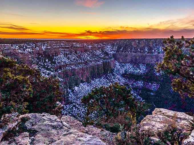 A sunset over a dusted canyon, proof that nature has absolutely no interest in being subtle about anything.